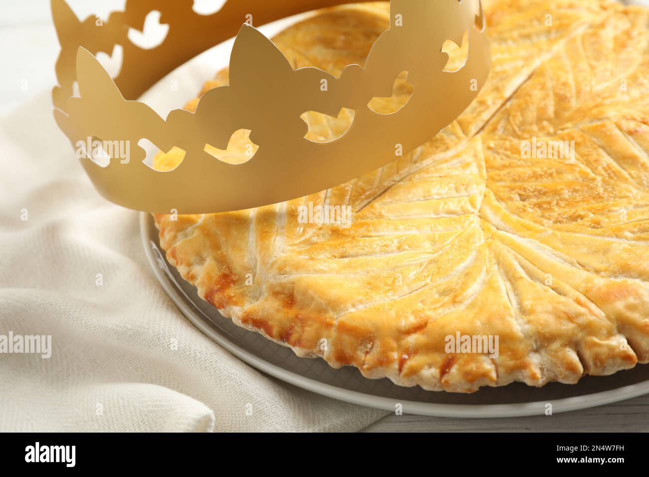 Traditional galette des Rois with paper crown on table, closeup Stock ...