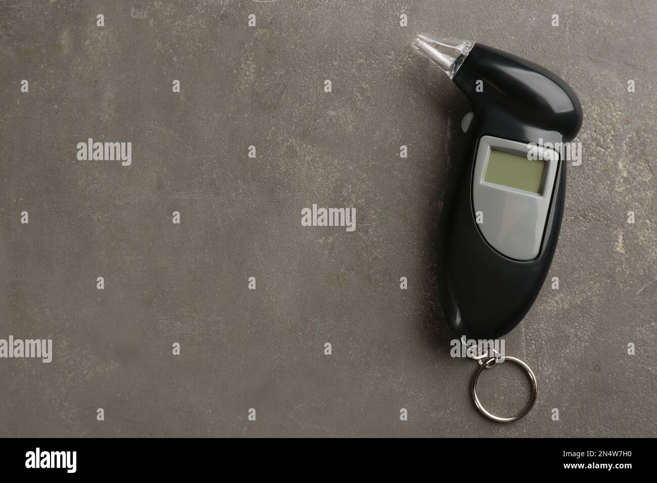 Modern breathalyzer with blank screen on grey stone table, top view ...