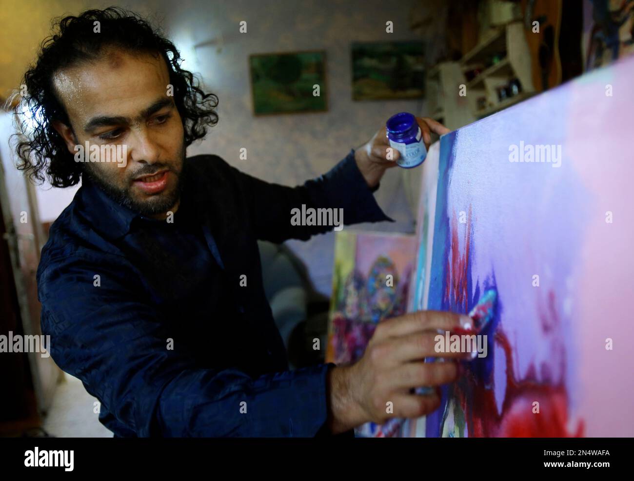 In this photo taken Wednesday, May 14, 2014, Palestinian artist Ismail ...