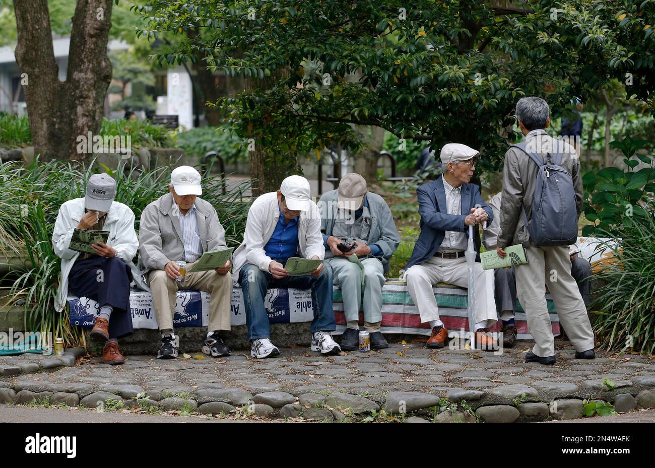 A group of men rest in a park in Tokyo Thursday, May 15, 2014. (AP ...
