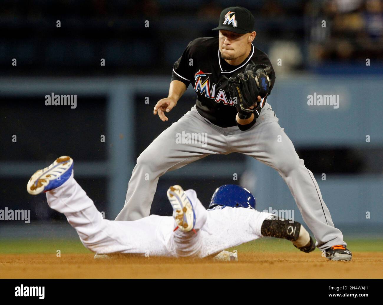 Los Angeles Dodgers’ Dee Gordon, below, slides in safely as the throw ...