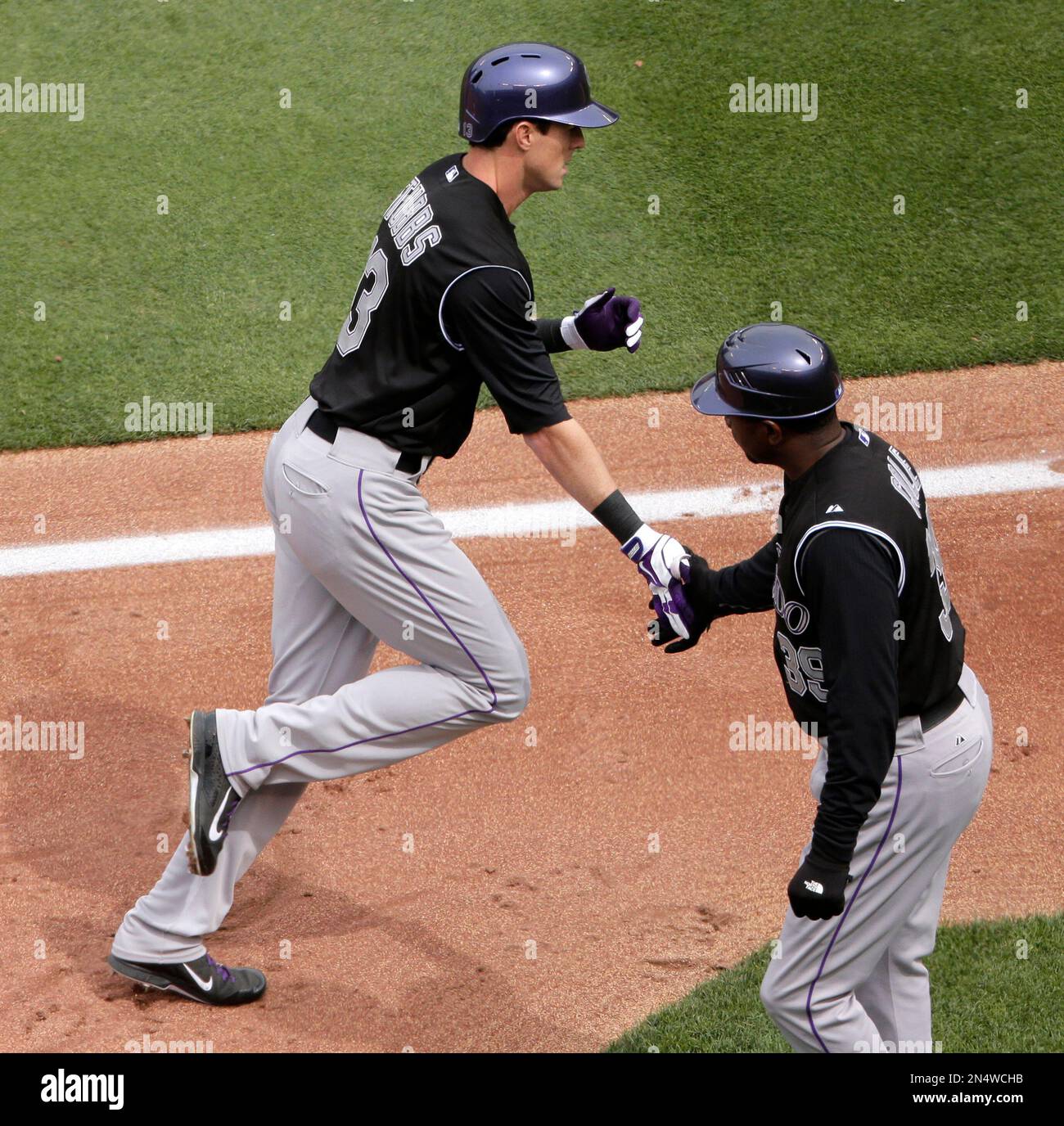 Colorado Rockies' Drew Stubbs, left, celebrates with third base coach ...