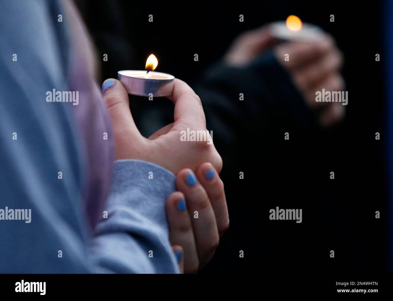 Mourners hold candles during a vigil for slain Brentwood, N.H. police ...