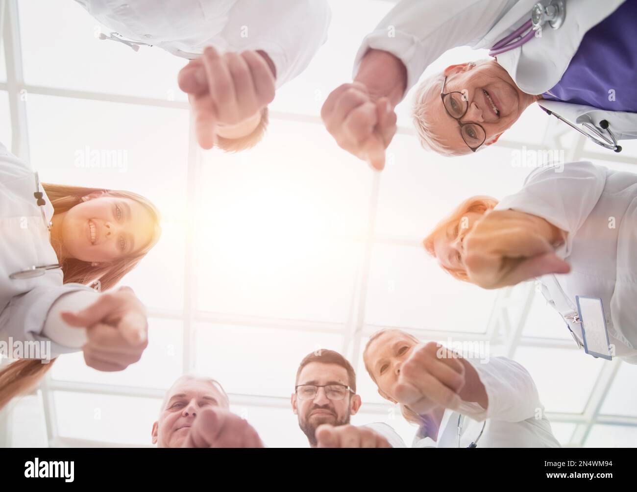 group of doctors standing in a circle and pointing at you Stock Photo ...
