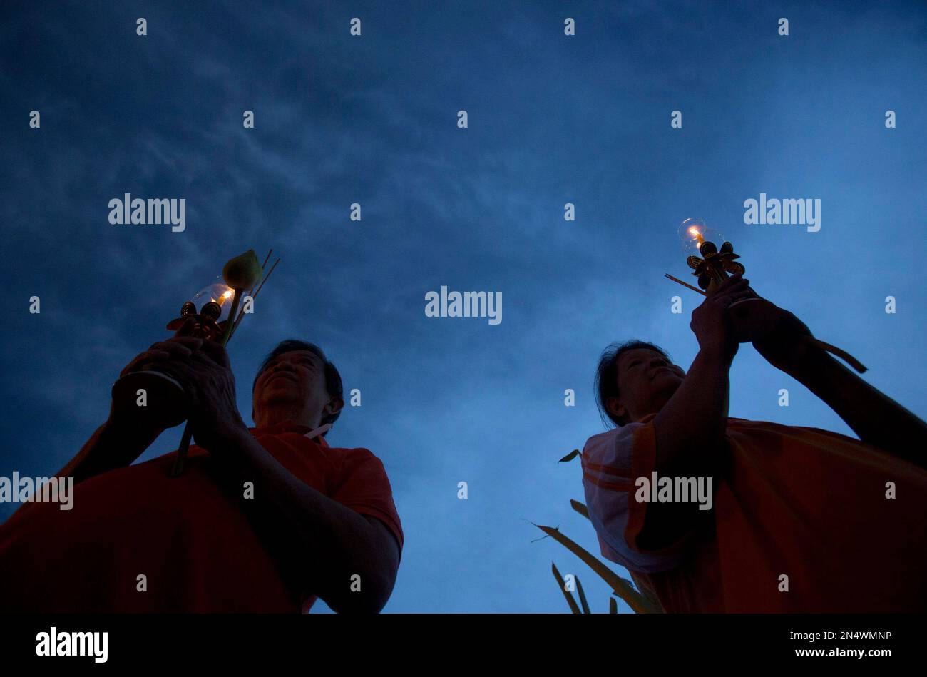 Thai Buddhists carrying lotus buds and candles pray in front of Marble ...