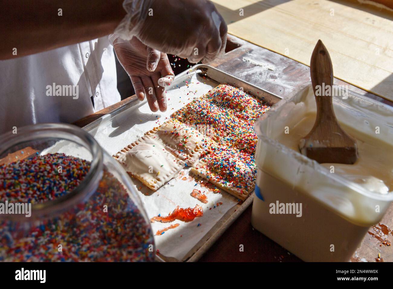 Gustavo Servellon applies sprinkles as he puts the finishing touches on ...