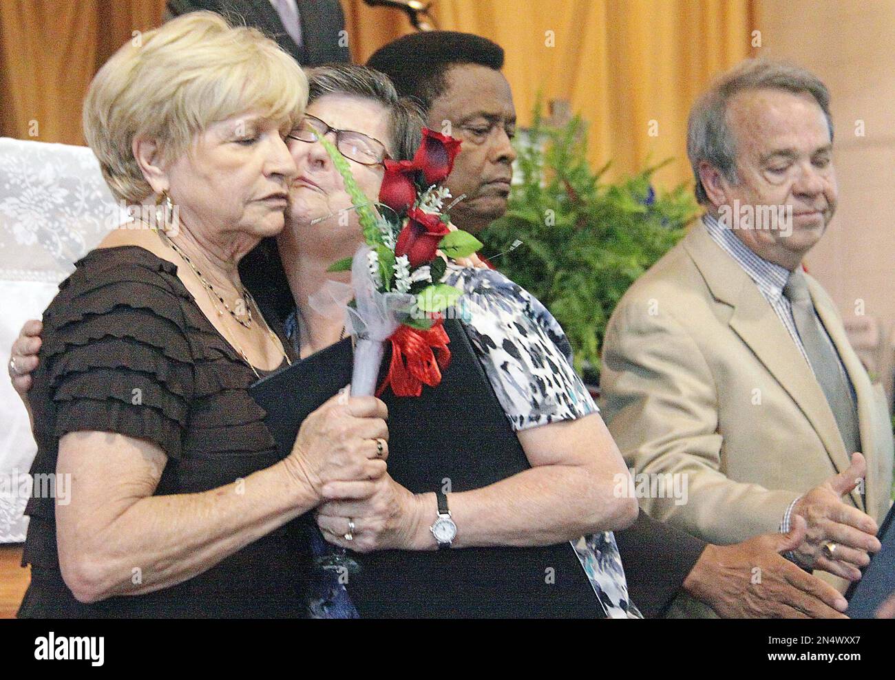 Connie Buggs, second from left, receives roses in honor of her mother ...