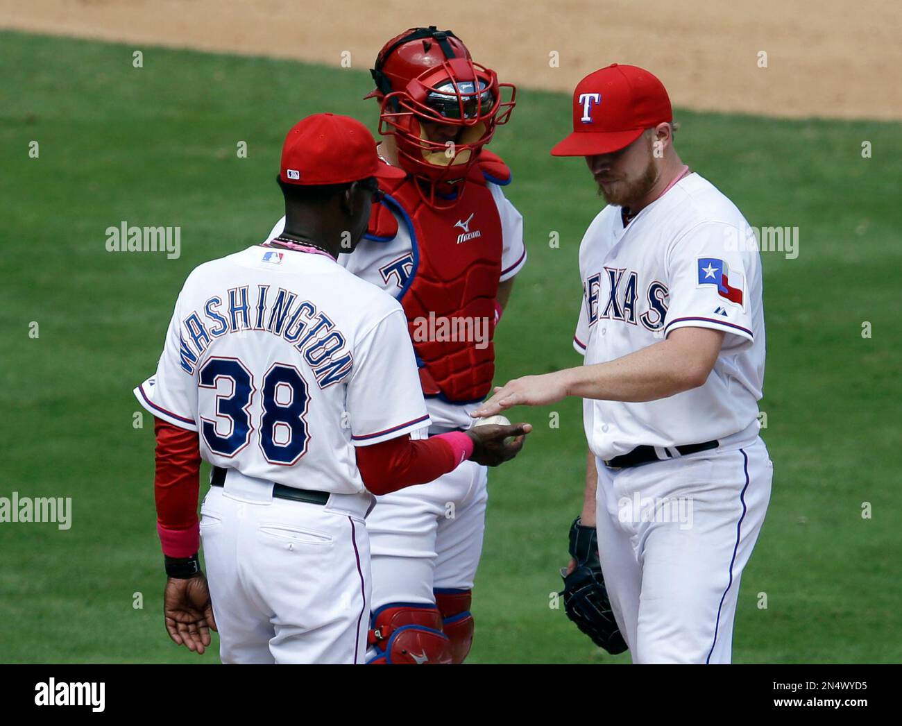 Texas Rangers manager Ron Washington, left, takes the ball from ...