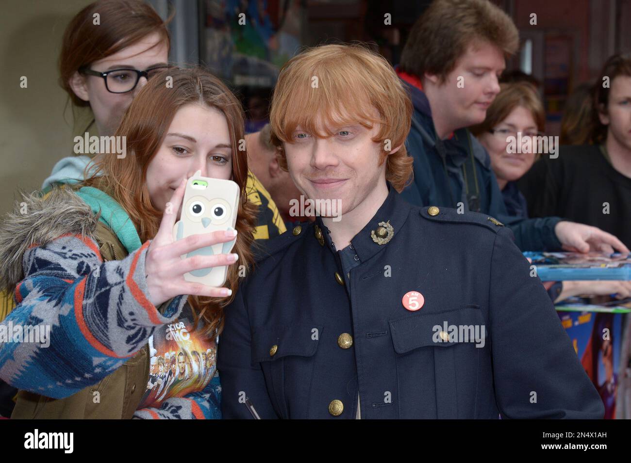 Rupert Grint poses for pictures with a fan on the red carpet for ...