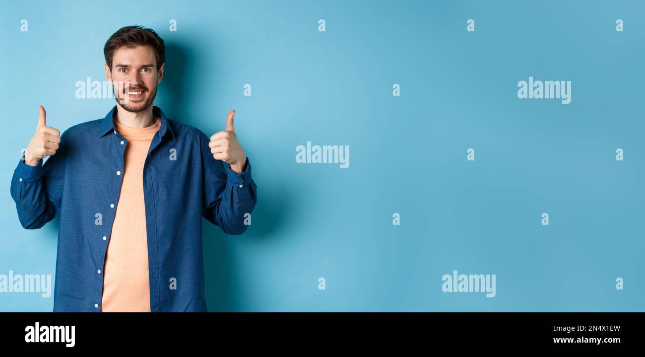 Handsome smiling man being supportive, showing thumbs up in approval ...