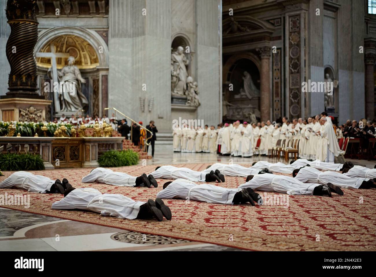 Thirteen new priests lay on the ground during a ceremony in which Pope ...