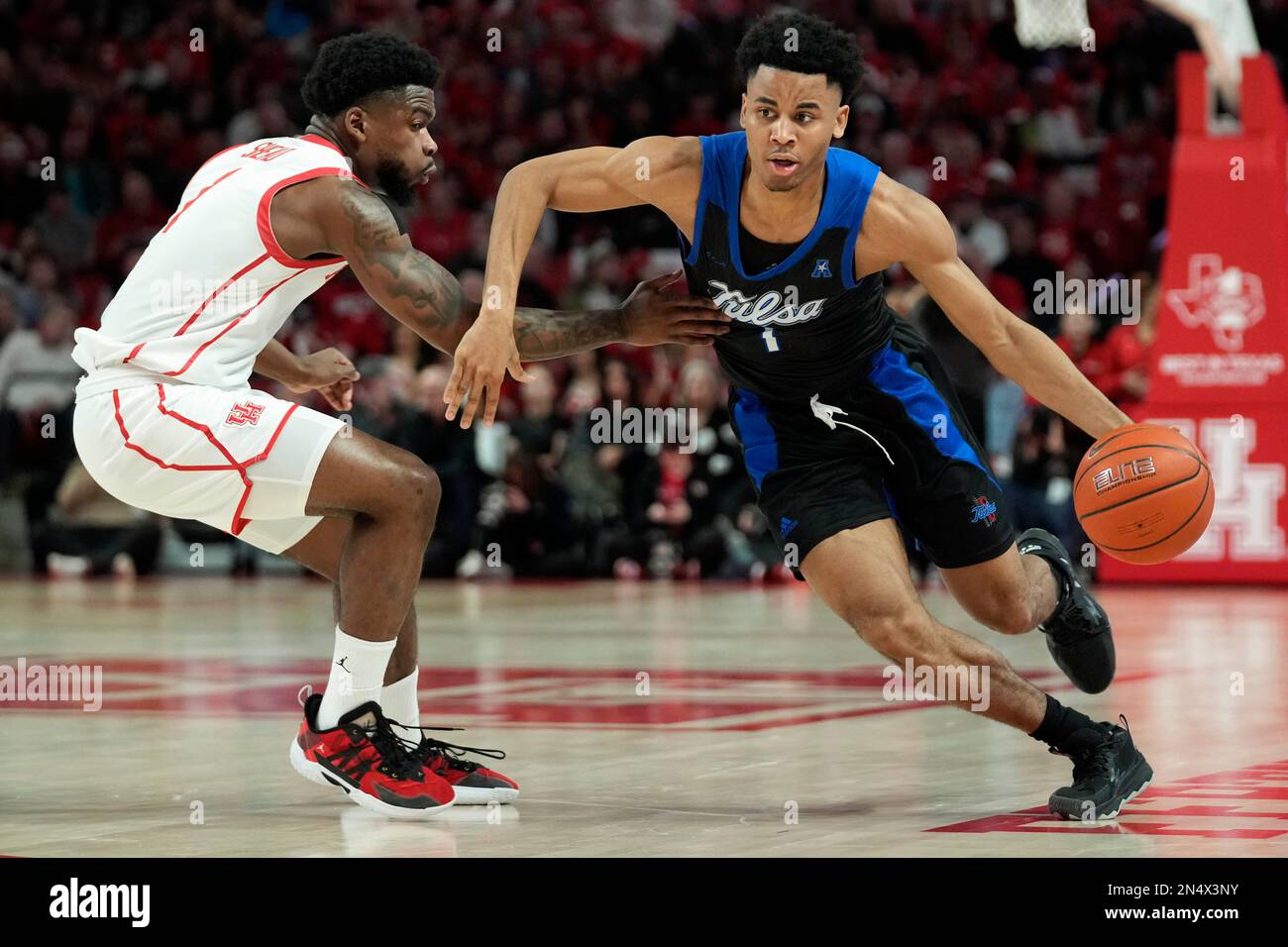 Tulsa guard Sam Griffin, right, dribbles as Houston guard Jamal Shead ...