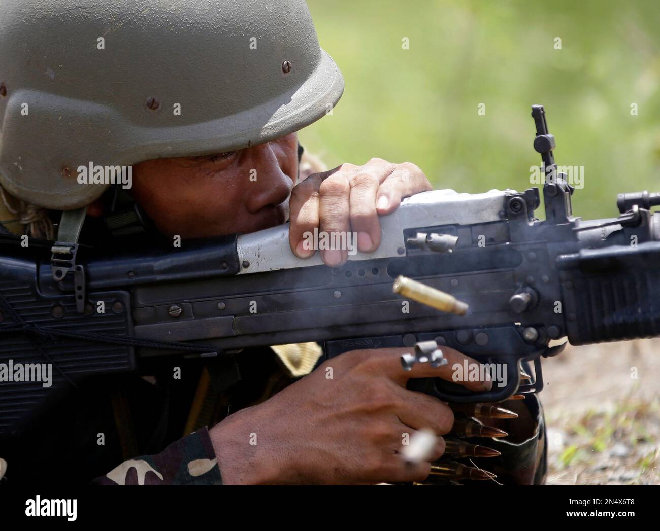 A Filipino soldier fires his machine-gun in a mock assault at a target ...