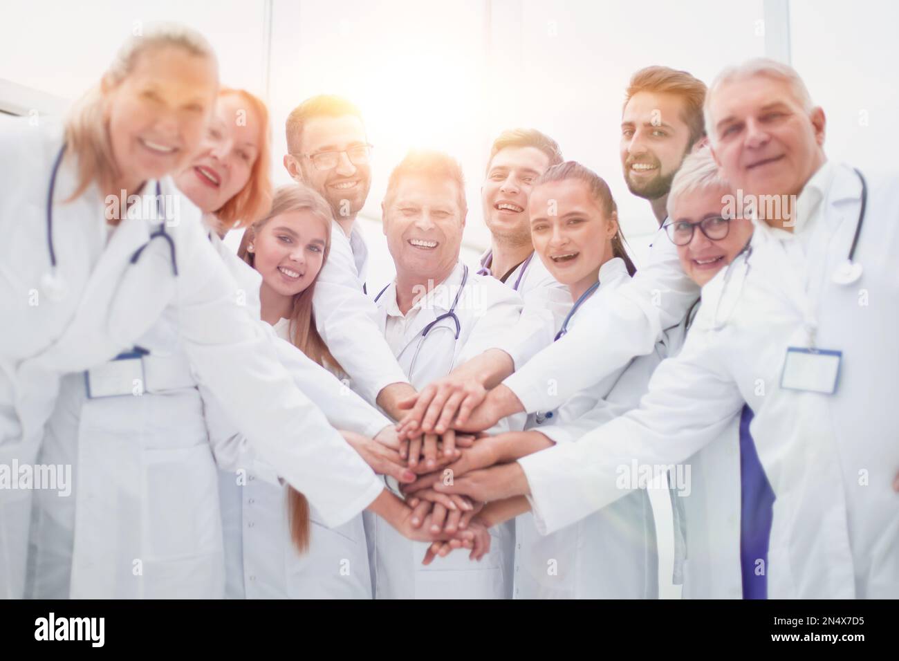 large group of doctors put their hands together Stock Photo - Alamy