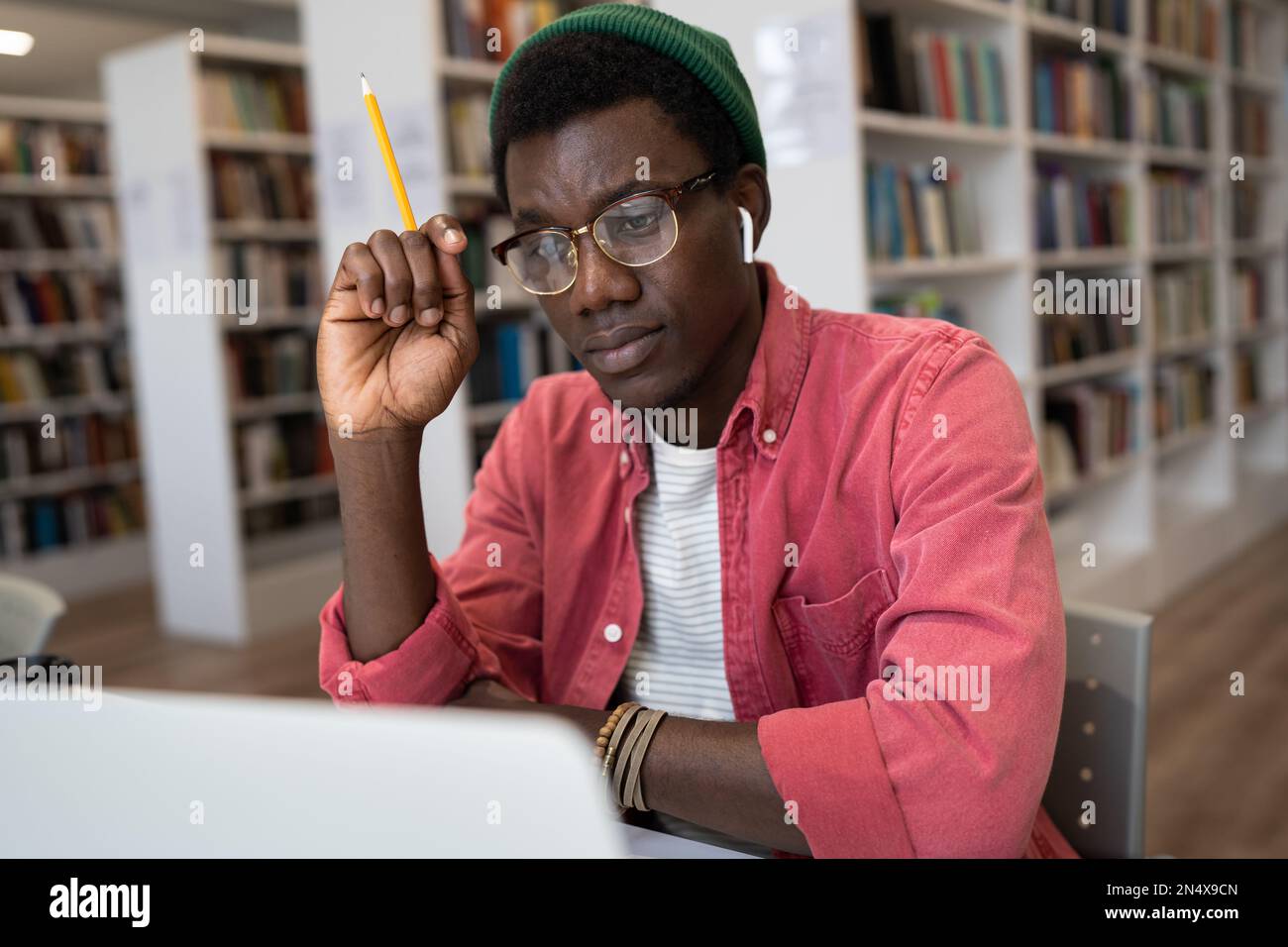 Focused African American student guy in glasses studying sitting in ...