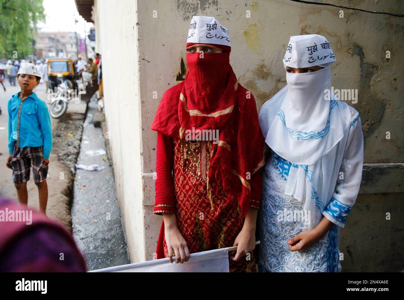 Indian girls wear Aam Aadmi Party (AAP), or the common man party, caps ...