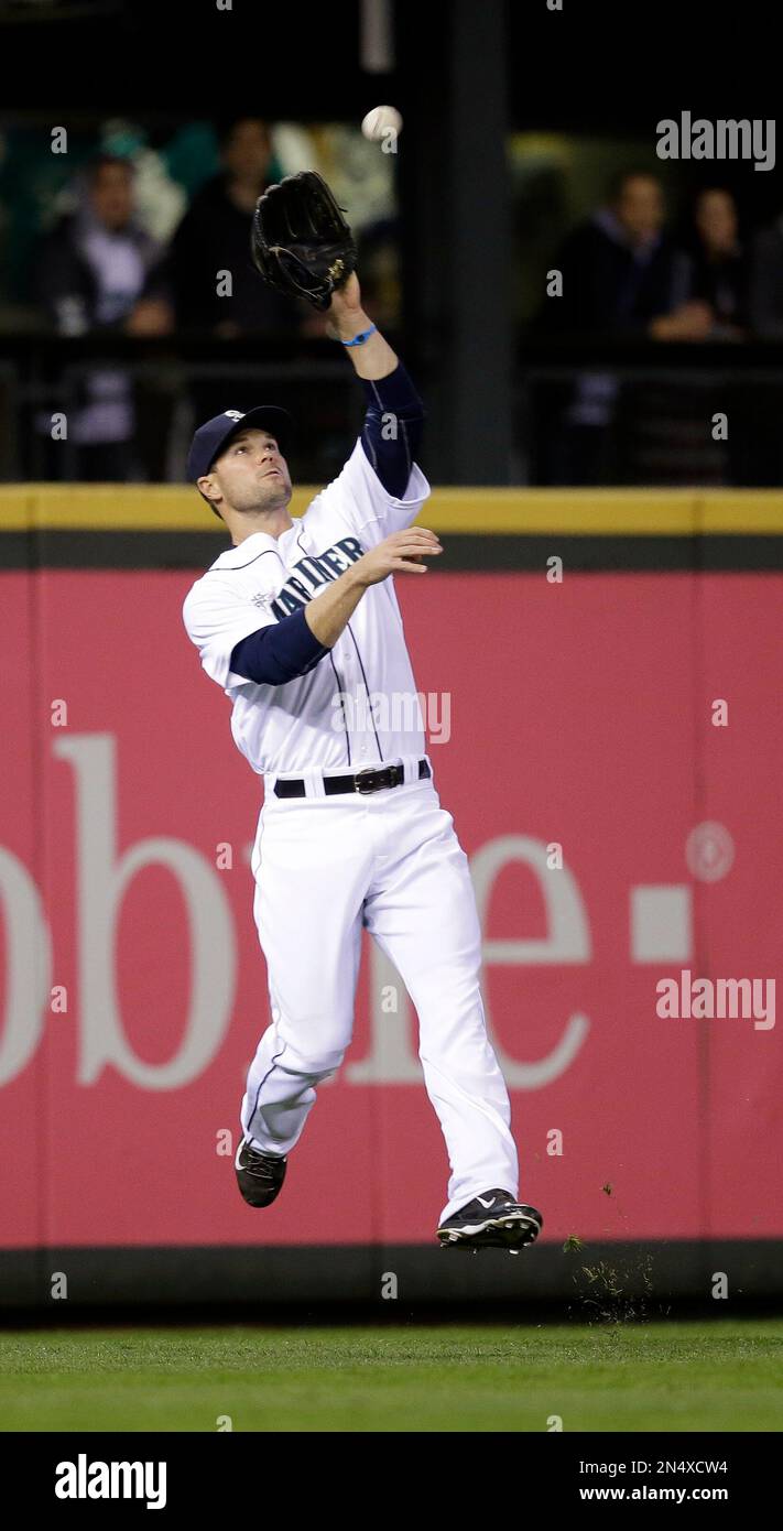 Seattle Mariners left fielder Cole Gillespie leaps to snag a fly ball ...