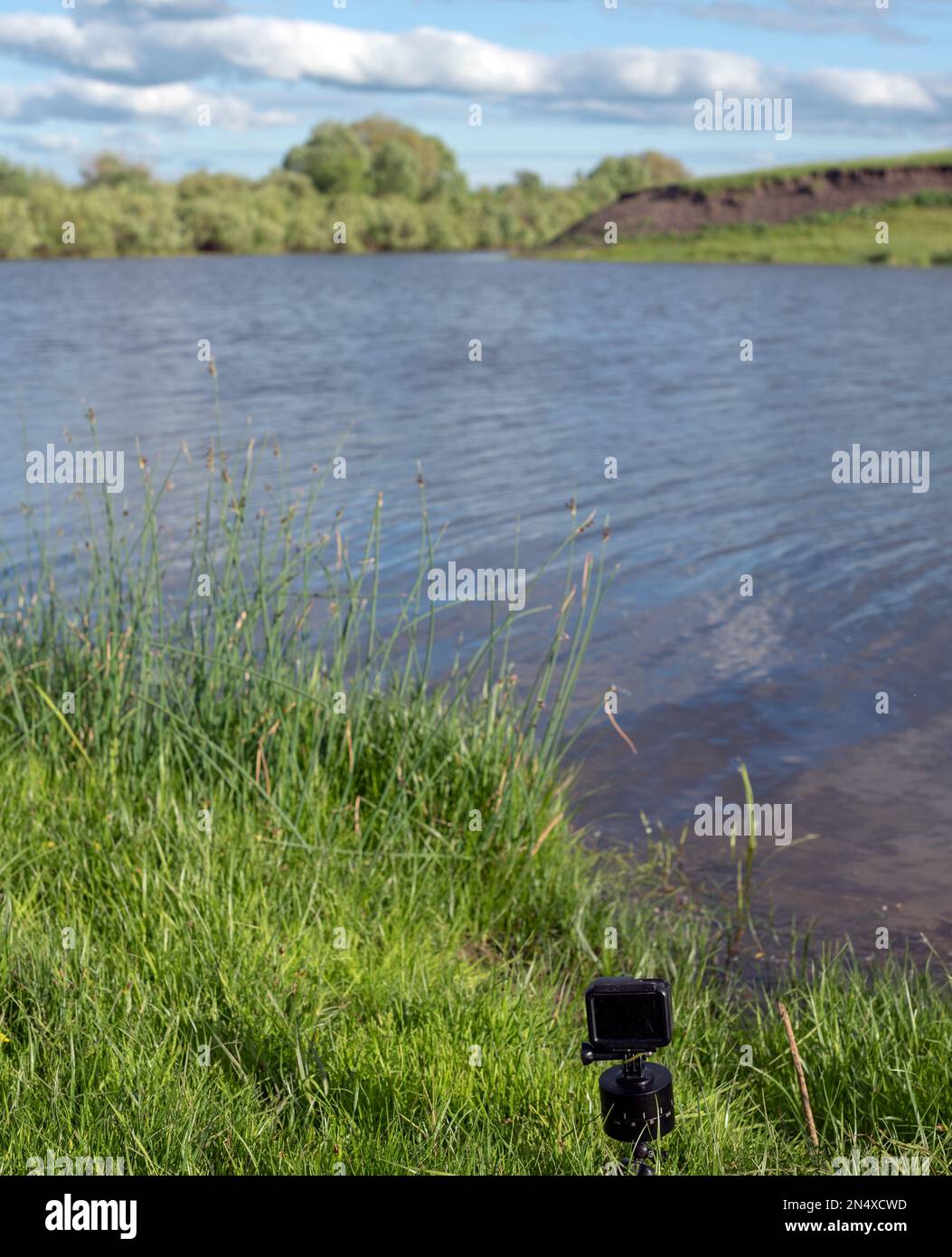 Action camera stands on a panoramic tripod head on the river Bank in ...