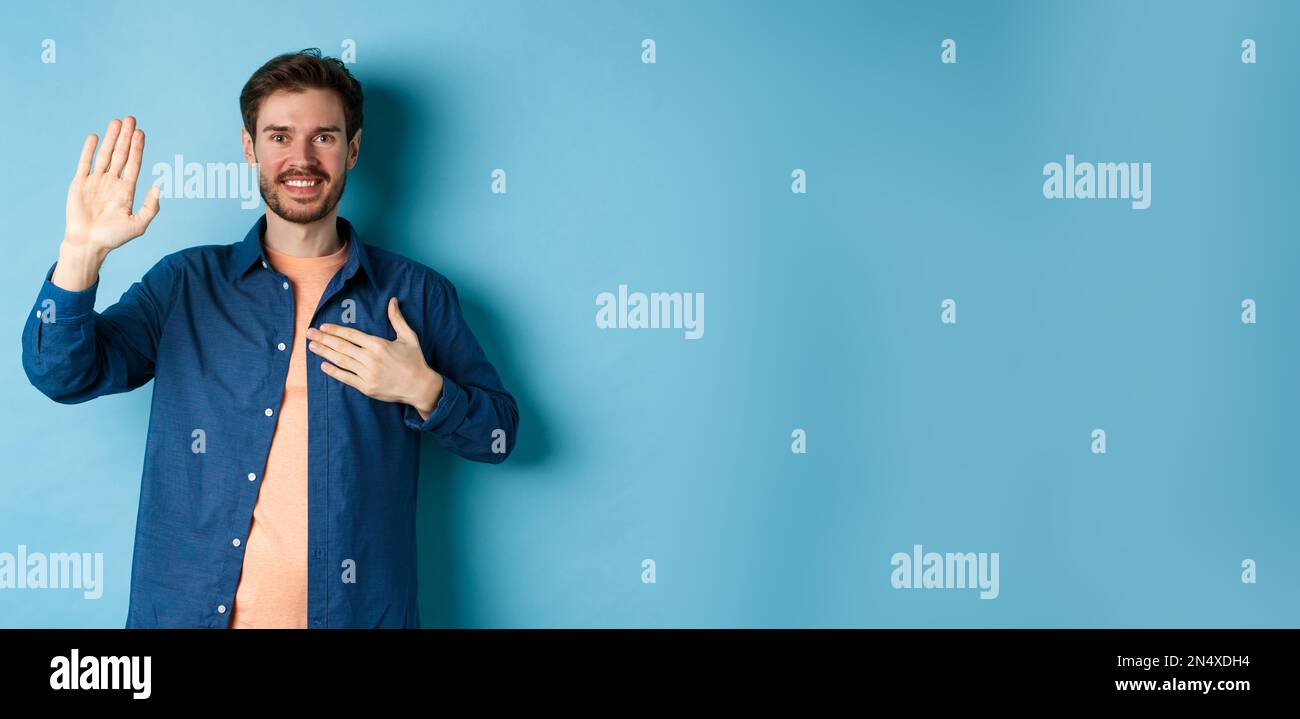 Happy young man introduce himself, telling truth with hand on heart and ...