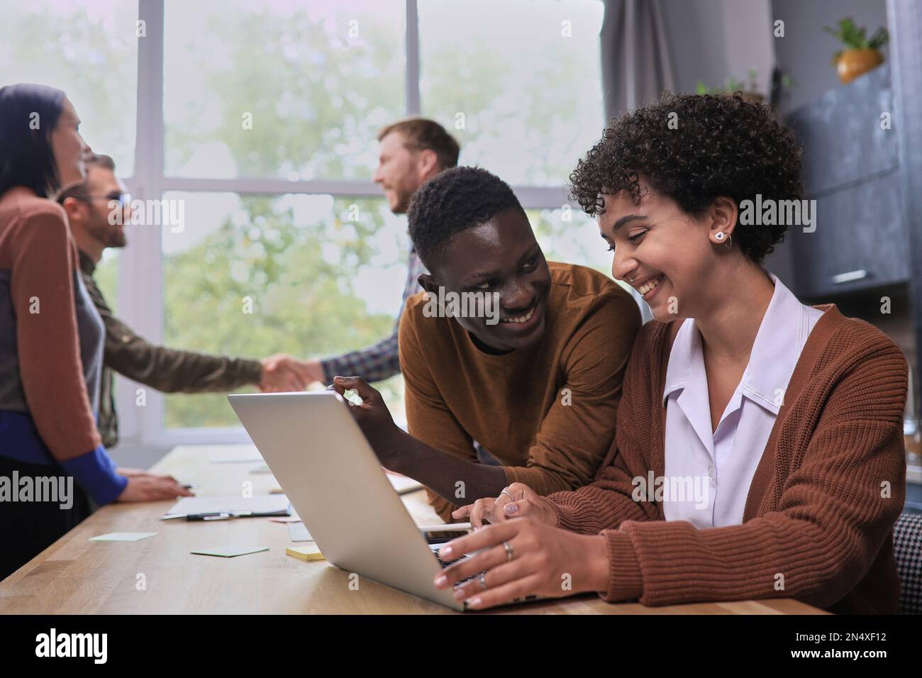 two professional businessmen discussing and using desktop computer in ...