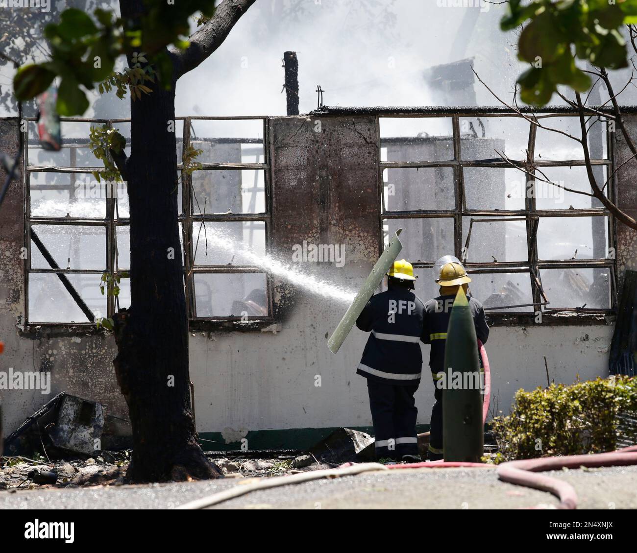 Firemen train their hose at the Explosives Ordnance Battalion barracks ...