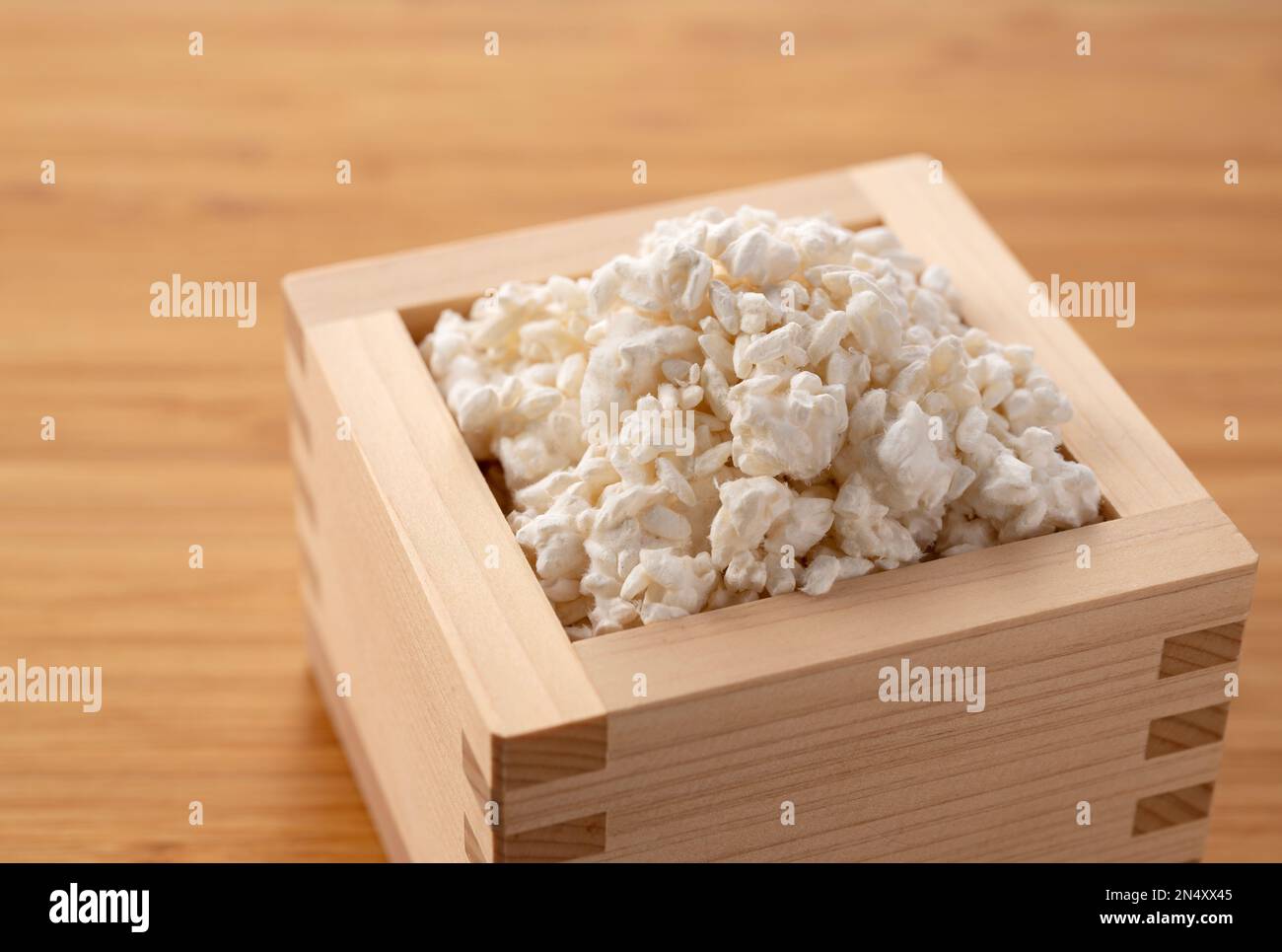 Rice koji in a Masu box placed against a wooden background. Koji mold ...