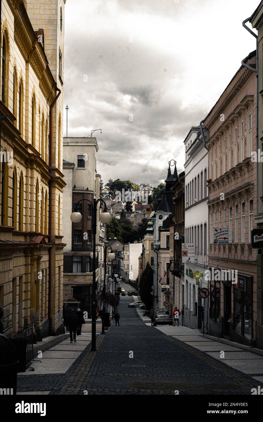A vertical shot of a street with walking people silhouette and ...