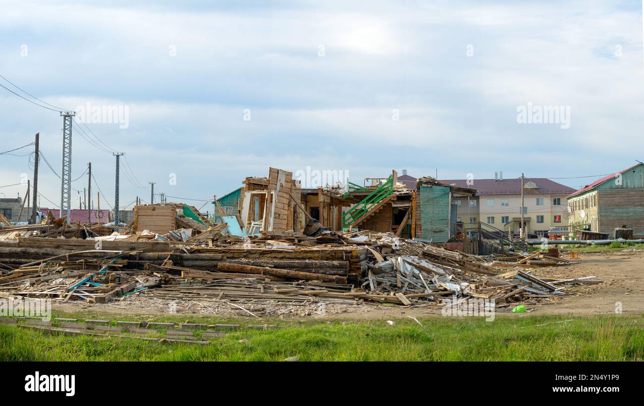 An old broken wooden house with the remains of stairs and floor stands ...