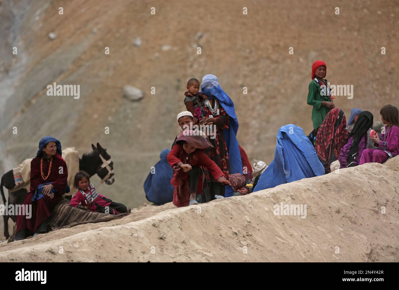 Survivors sit with their possessions near the site of Friday's ...