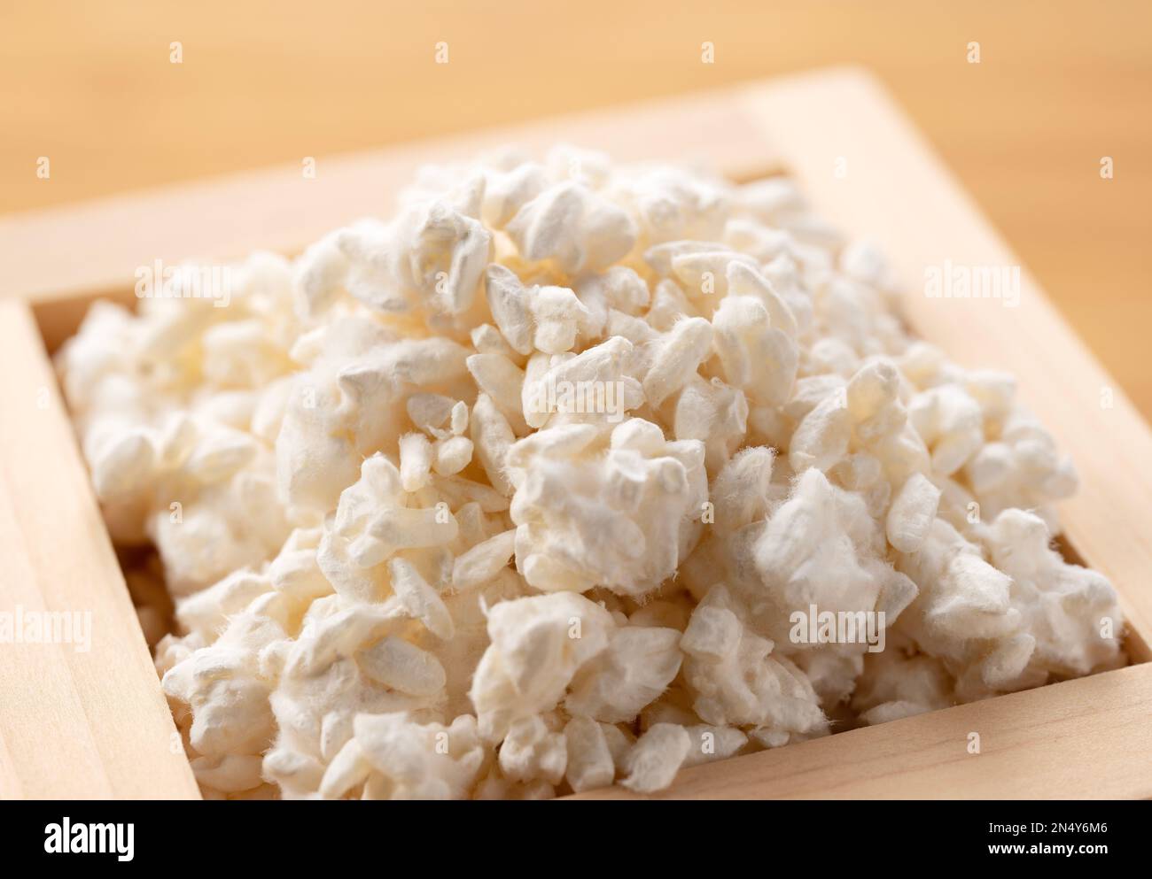 Rice koji in a Masu box placed against a wooden background. Koji mold ...