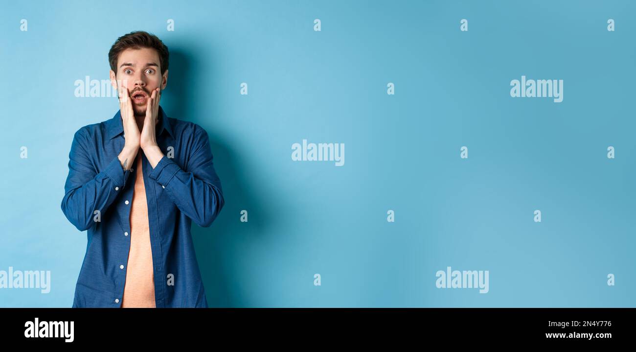 Portrait of guy gasping and dropping jaw with shocked face, staring at ...