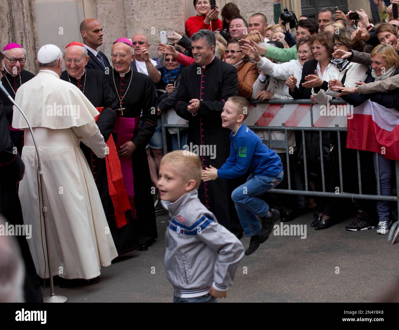 Children jump next to Pope Francis as he leaves St. Stanislaus church ...