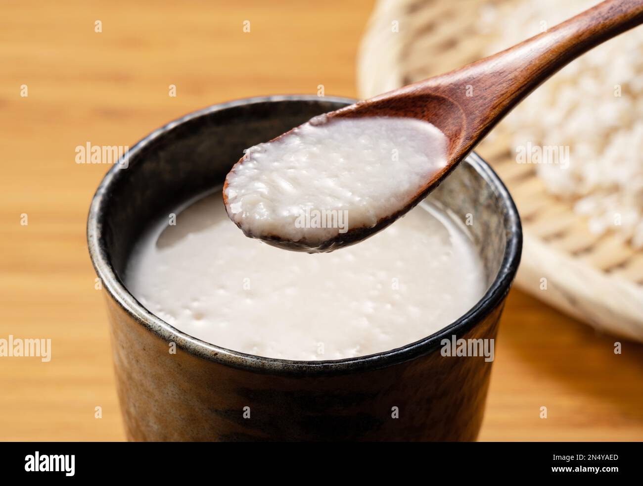 Amazake and a wooden spoon on the table. Amazake is a traditional ...