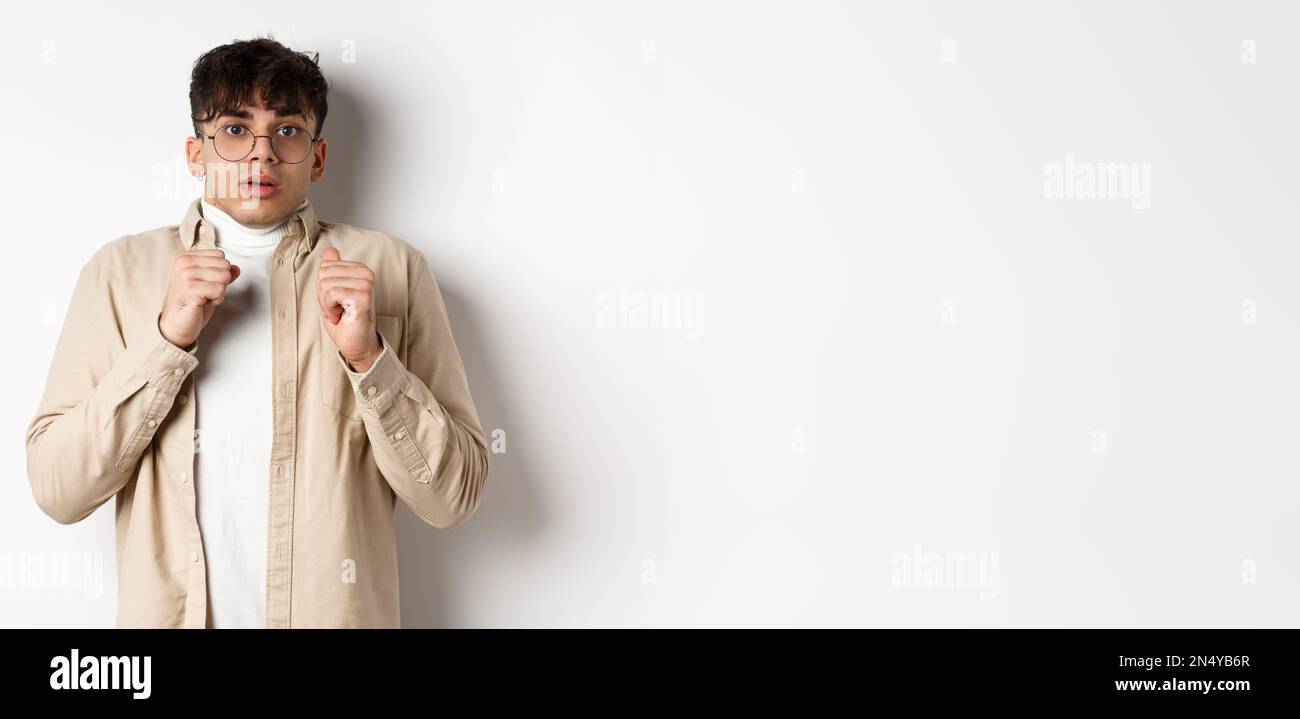 Startled man freeze from fear, gasping and looking scared at camera ...