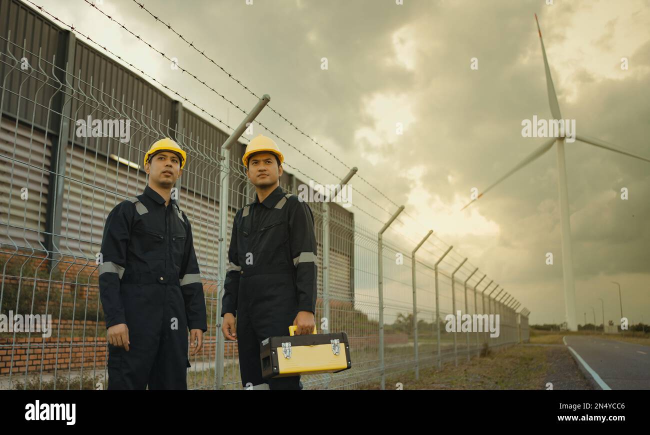 Two technician engineer in uniform with standing and checking wind ...