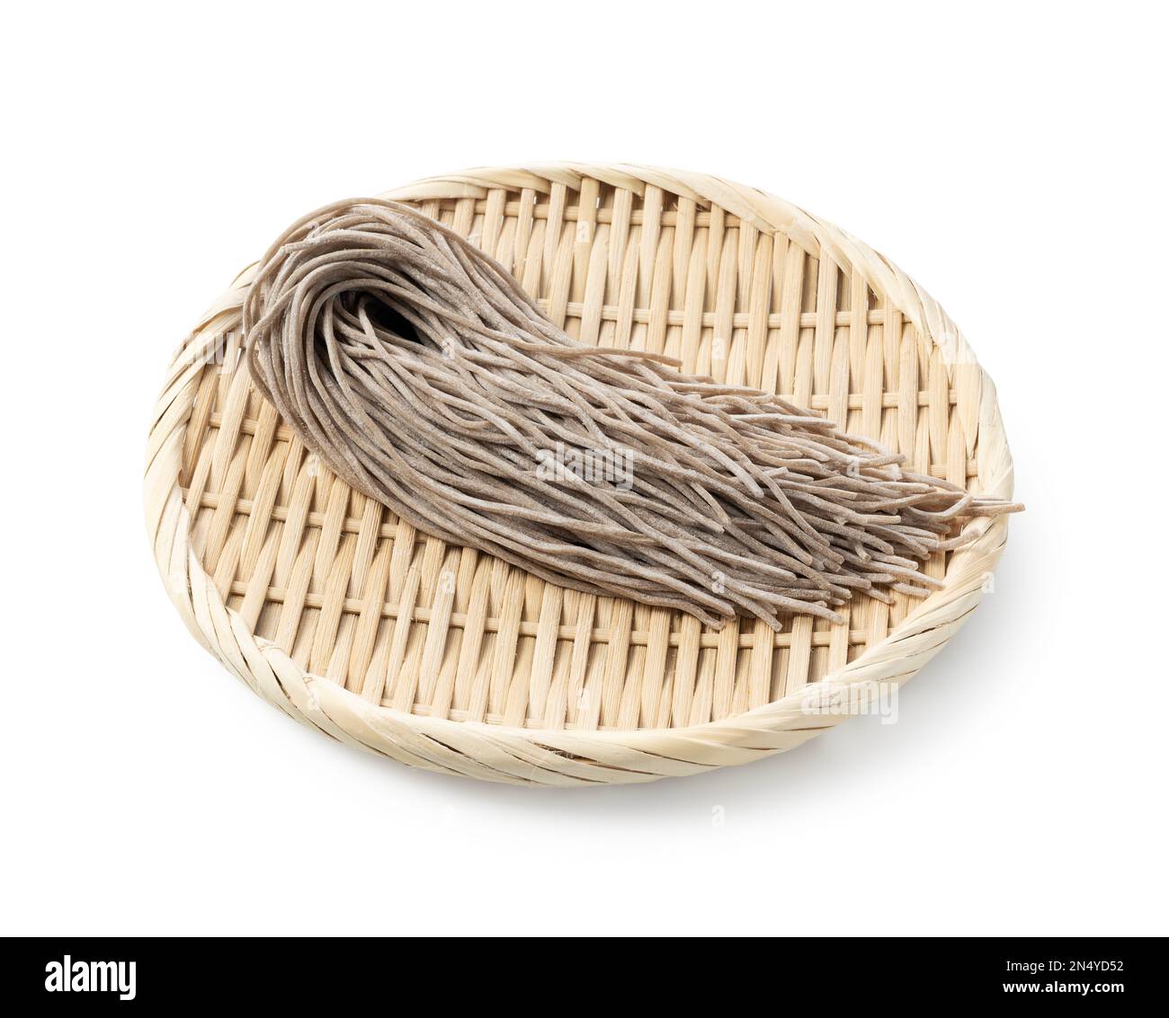 Raw soba noodles in a bamboo colander placed against a white background ...