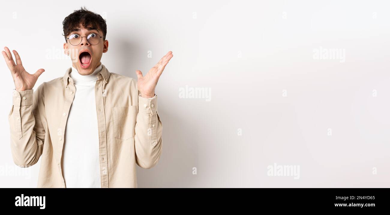 Scared young man in panic, screaming and looking axious, jumping ...