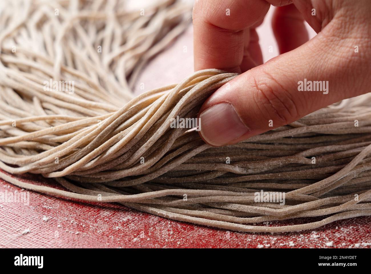A man's hand holding raw soba noodles. Soba before boiling. Freshly ...