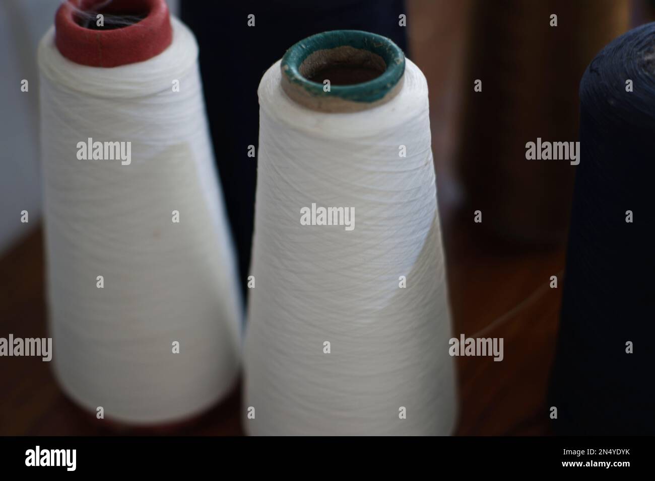 A Spool Of White Thread Against A Tabletop Background Stock Photo - Alamy