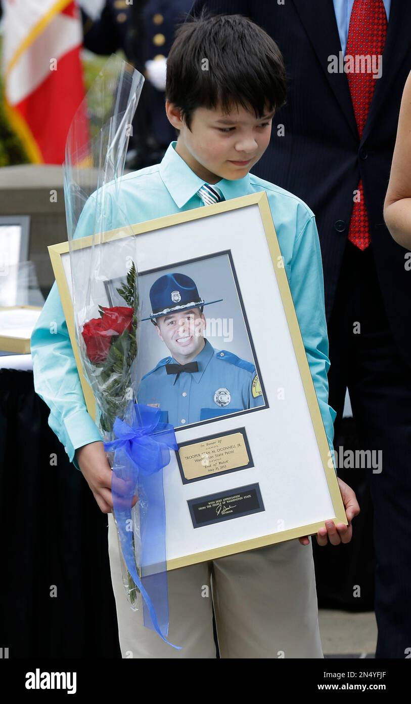 Kian O'Connell, 8, the son of fallen Washington State Patrol Trooper Sean O'Connell Jr., carries ...