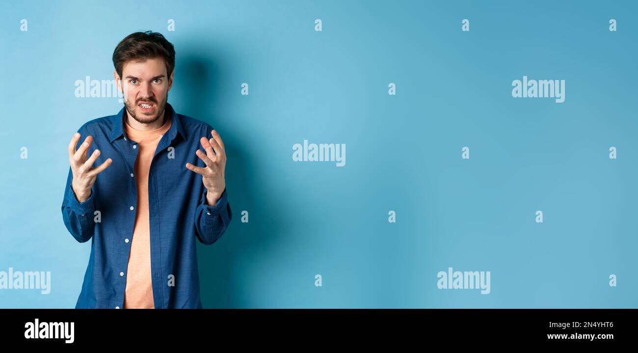 Annoyed and angry man raising hands and clench teeth outraged, stare ...