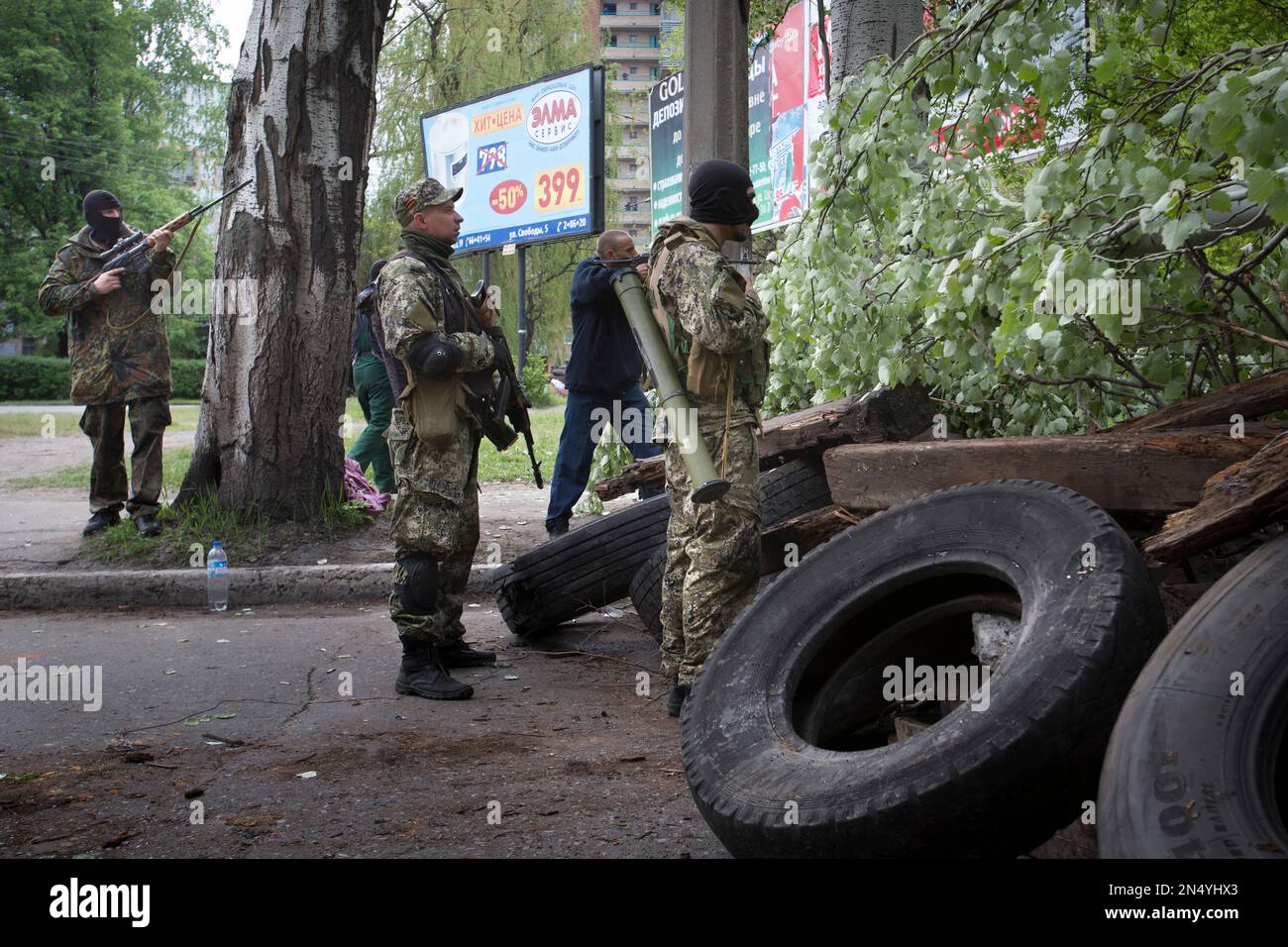 Pro-Russian gunmen stand with their weapons behind barricades in ...