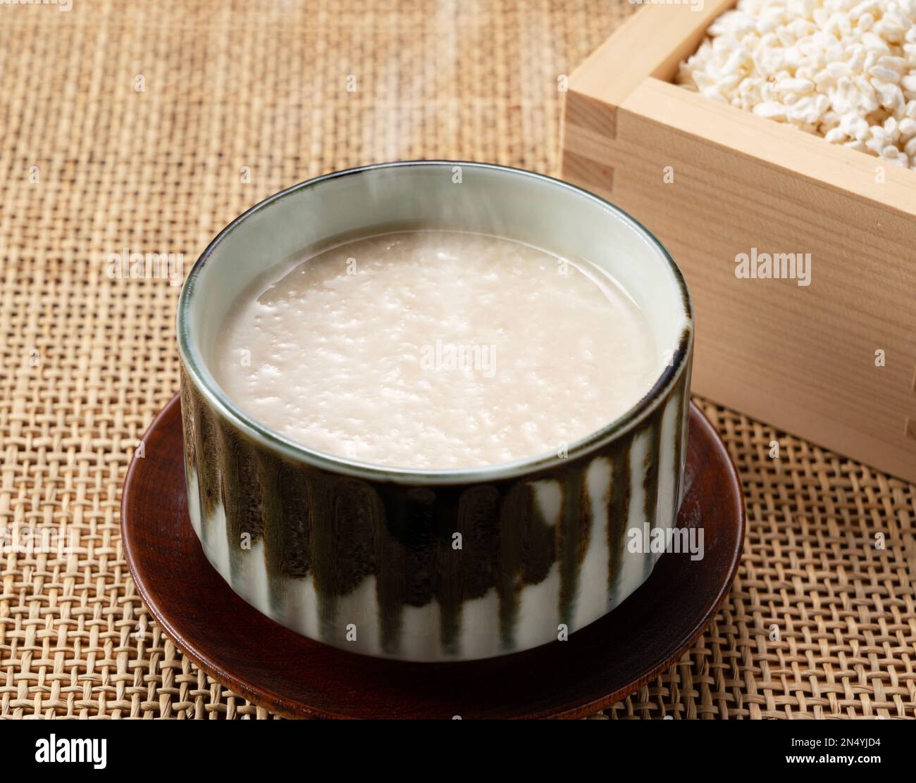 Amazake and rice malt in a Masu box on the table. Amazake is a ...