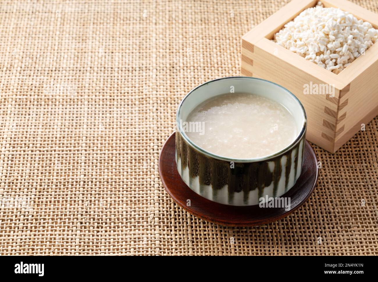Amazake and rice malt in a Masu box on the table. Amazake is a ...