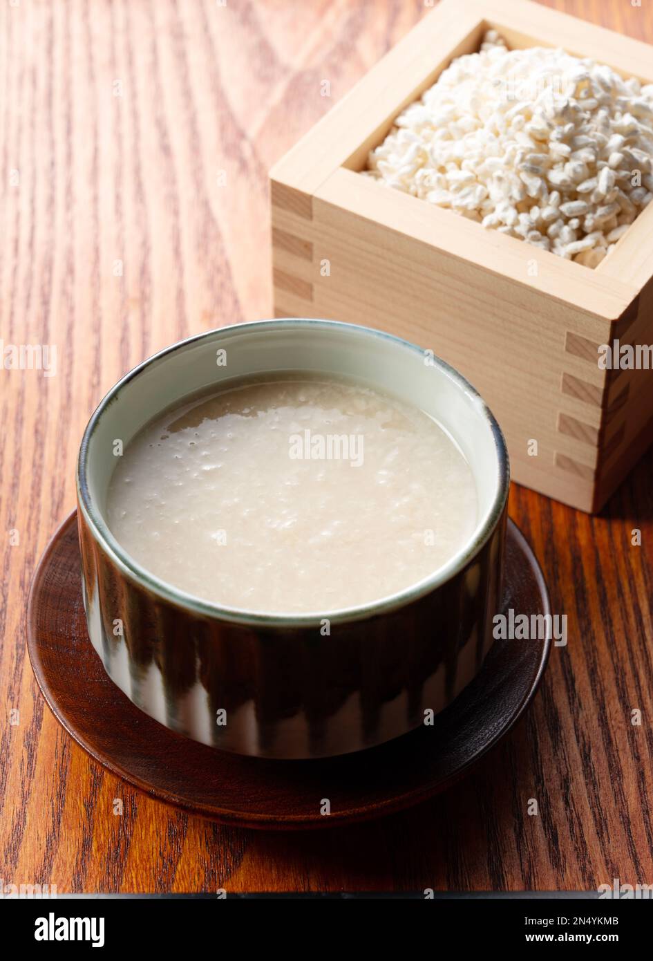Amazake and rice malt in a Masu box on the table. Amazake is a ...