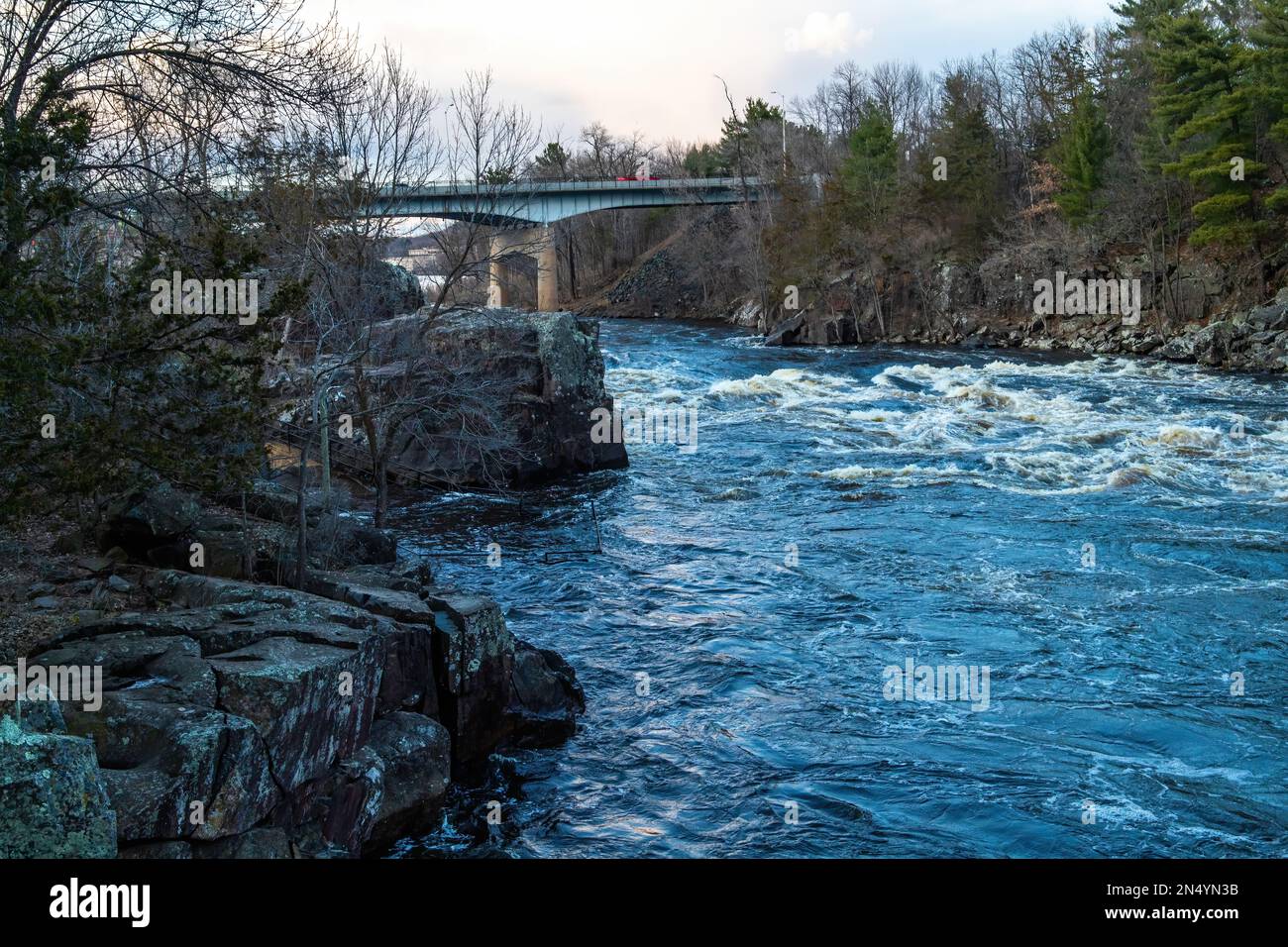 St. Croix River with white rapids in the evening with the rocks of Interstate State Park on the ...