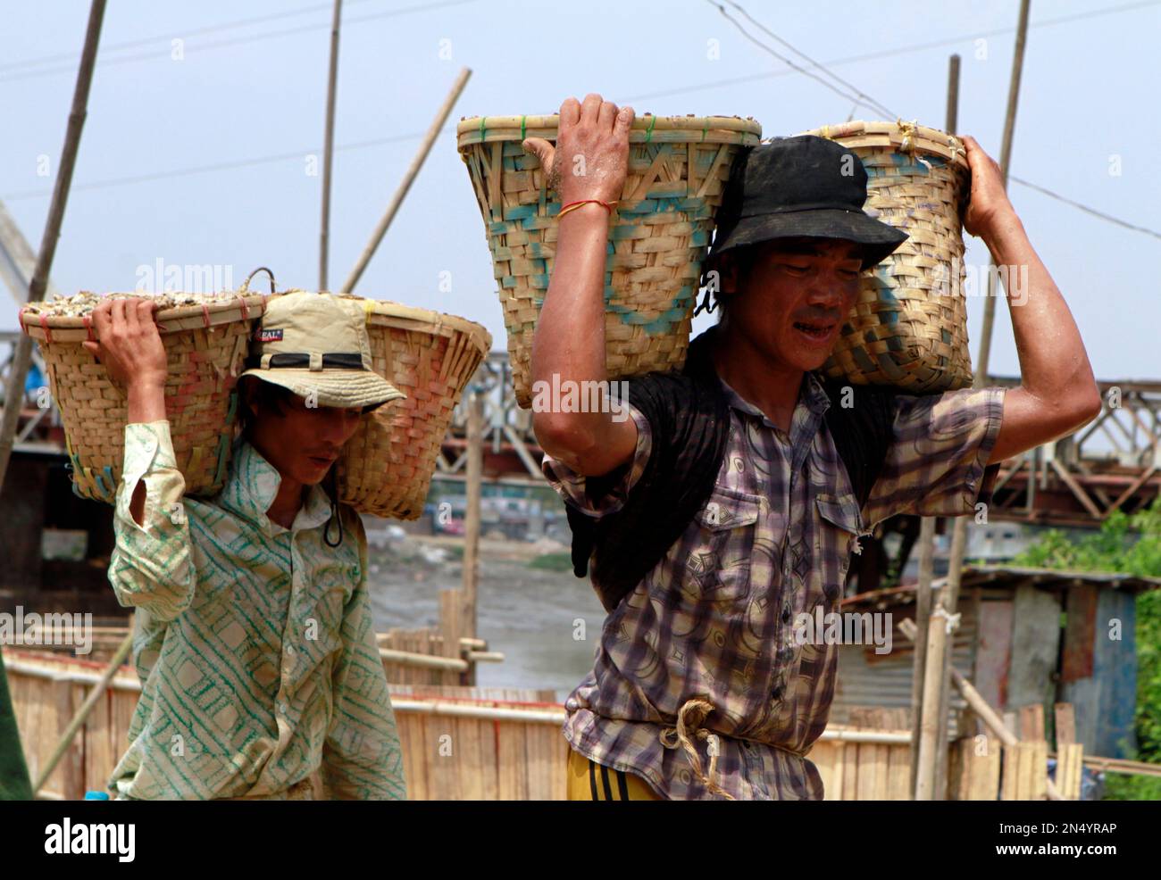 In this photo taken on April 30, 2014, daily waged workers unload sands ...