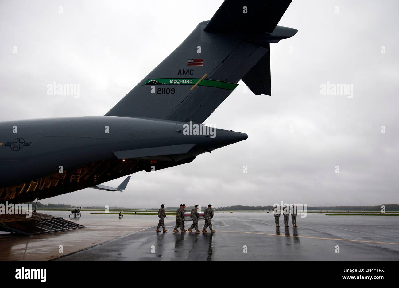 A U.S. Army carry team moves a transfer case containing the remains of ...
