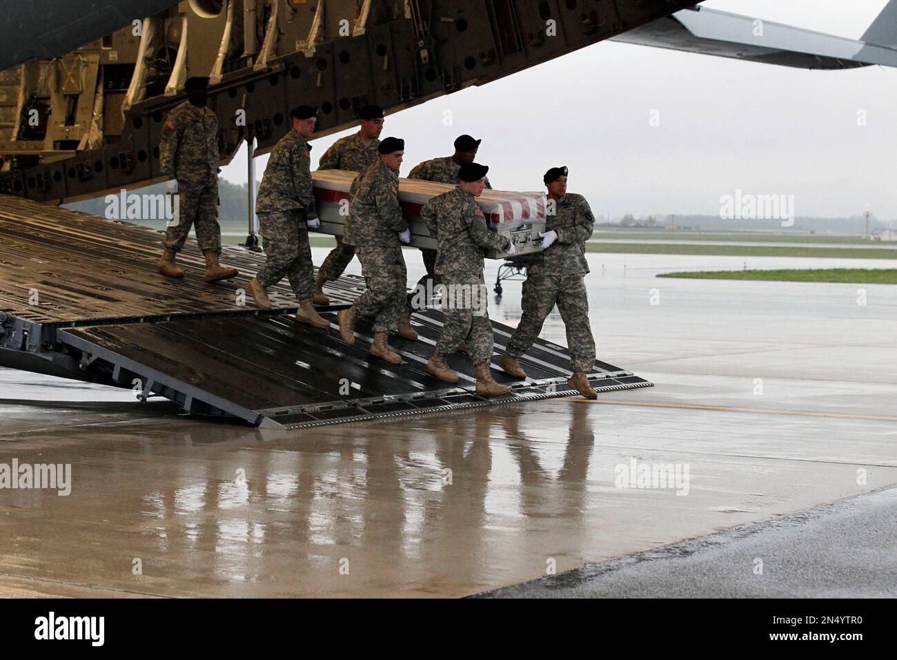 A U.S. Army carry team moves a transfer case containing the remains of ...