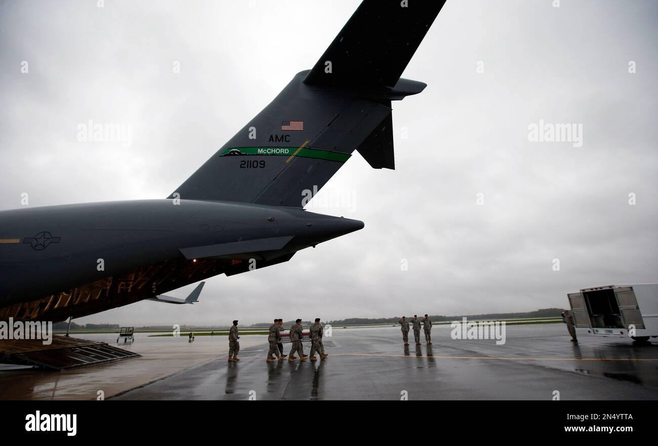 A U.S. Army carry team moves a transfer case containing the remains of ...